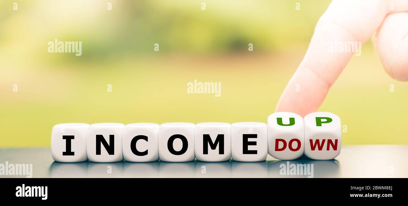 Hand turns dice and changes the expression "income down" to "income up ...
