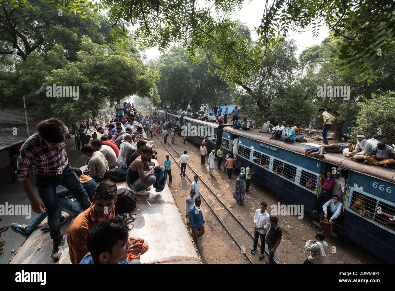 Passengers on top of overcrowded train at a train station in rural ...