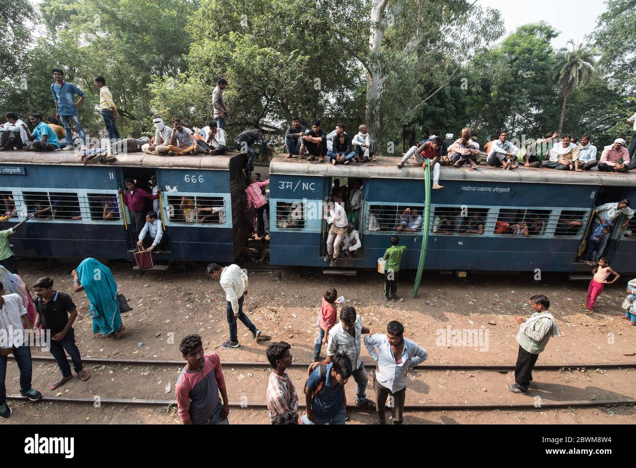 Passengers on top of overcrowded train at a train station in rural ...