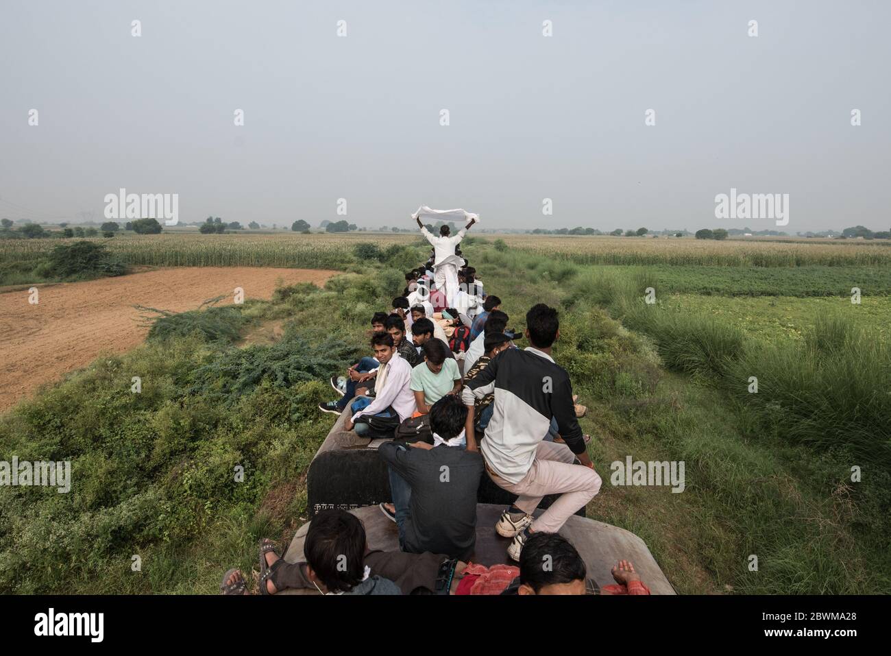 Men on top of overcrowded train passing through countryside in Madhya ...