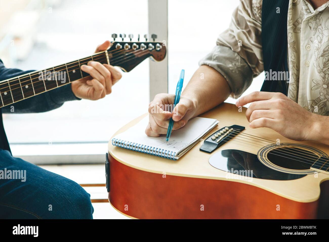 Learning to play the guitar. The teacher explains to the student the ...