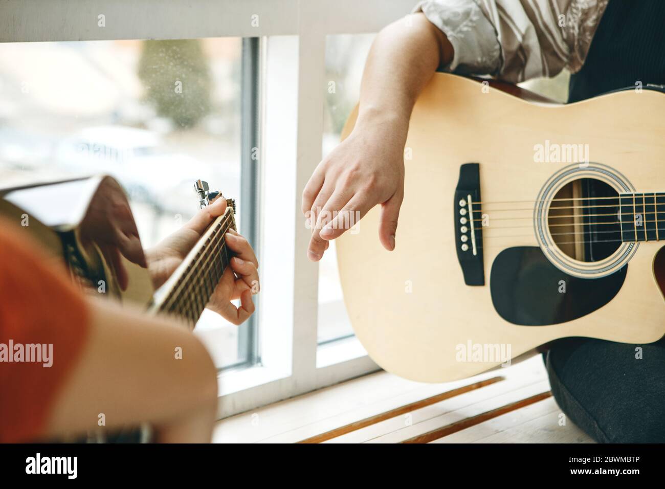 Learning to play the guitar. The teacher explains to the student the ...