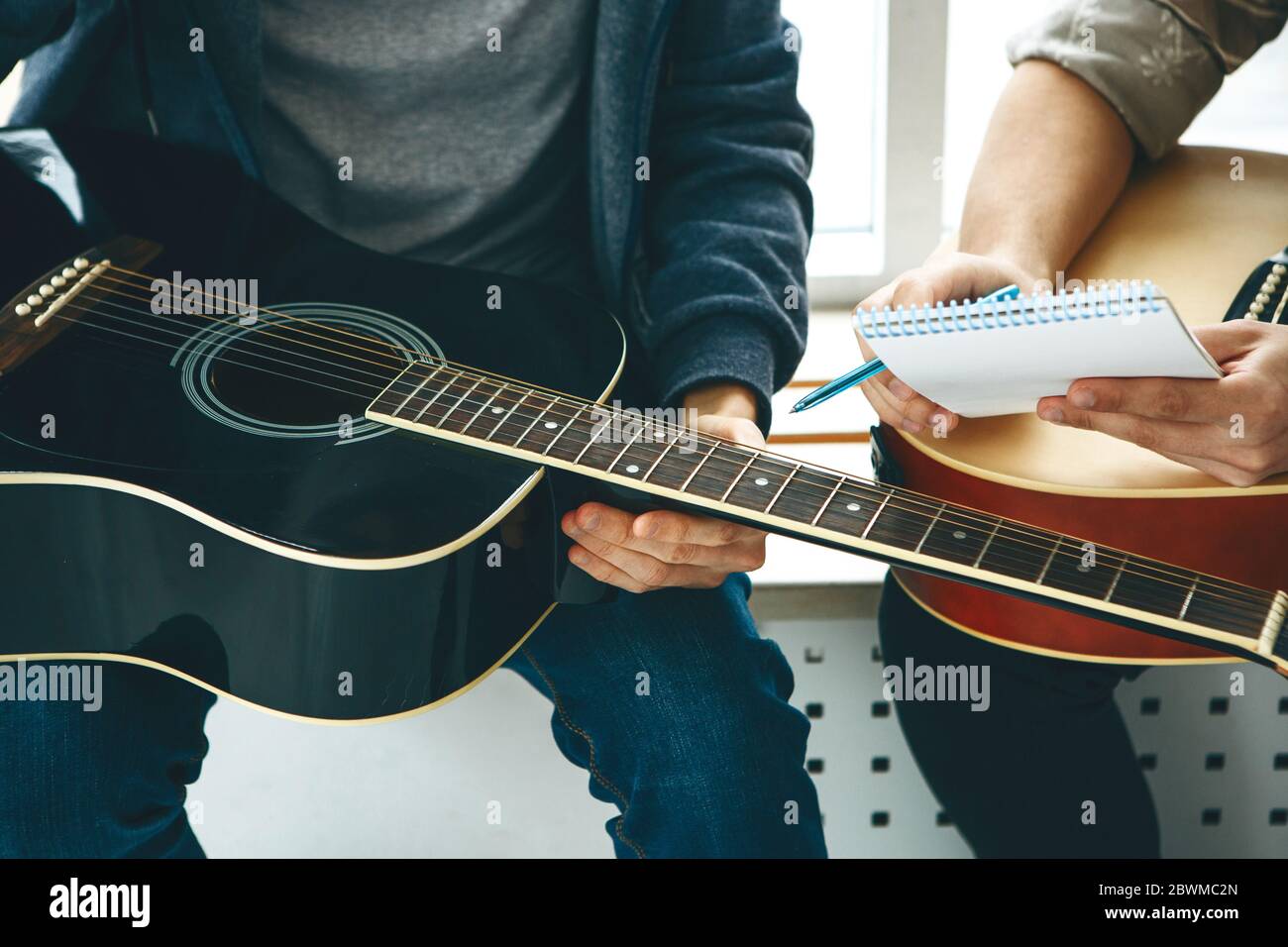 Learning to play the guitar. The teacher explains to the student the ...