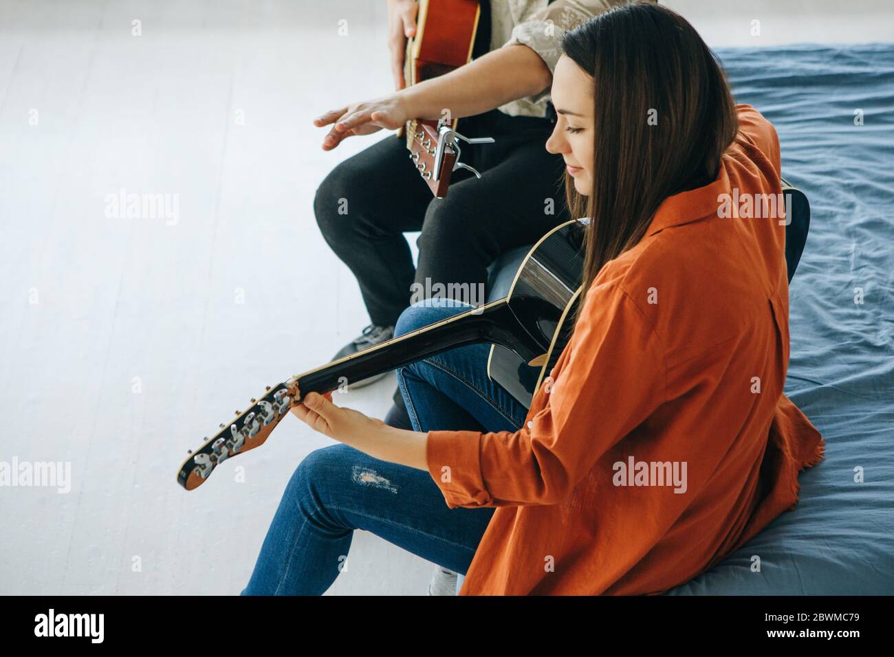 Learning to play the guitar. The teacher explains to the student the ...
