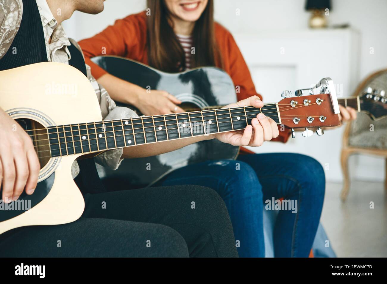 Learning to play the guitar. The teacher explains to the student the ...