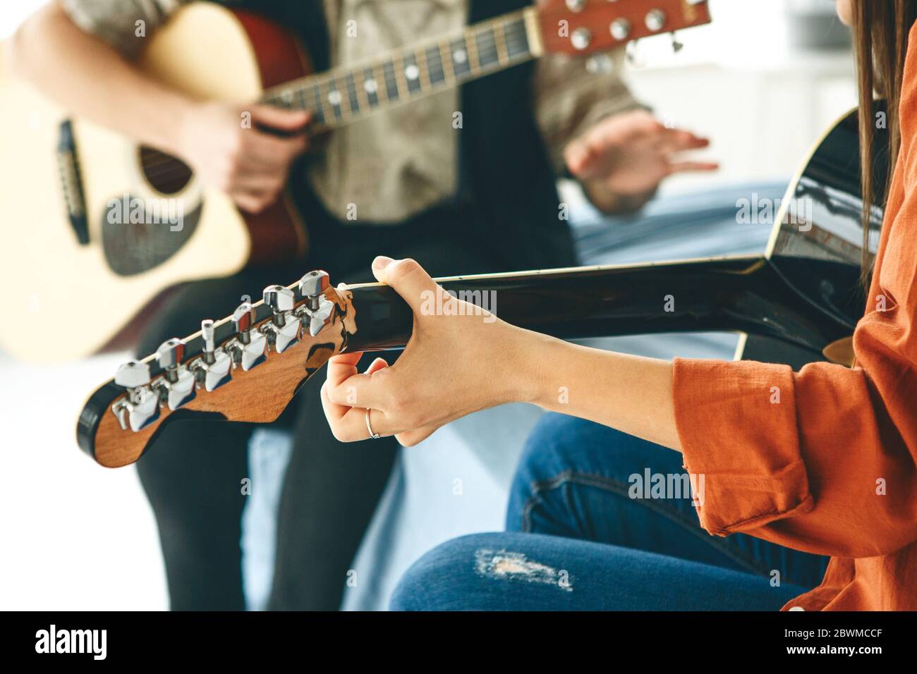 Learning to play the guitar. The teacher explains to the student the ...