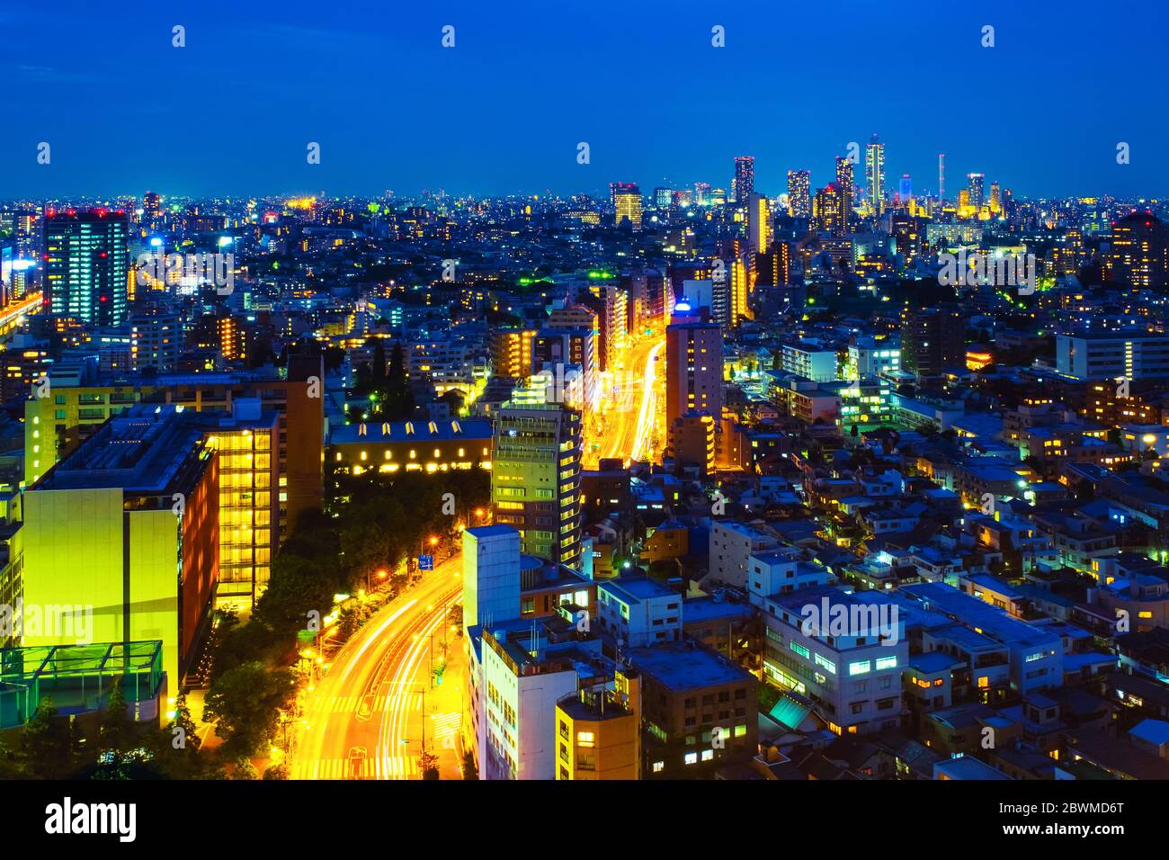 Tokyo, Japan. Skyline at night with illuminated road. Blue sky over ...