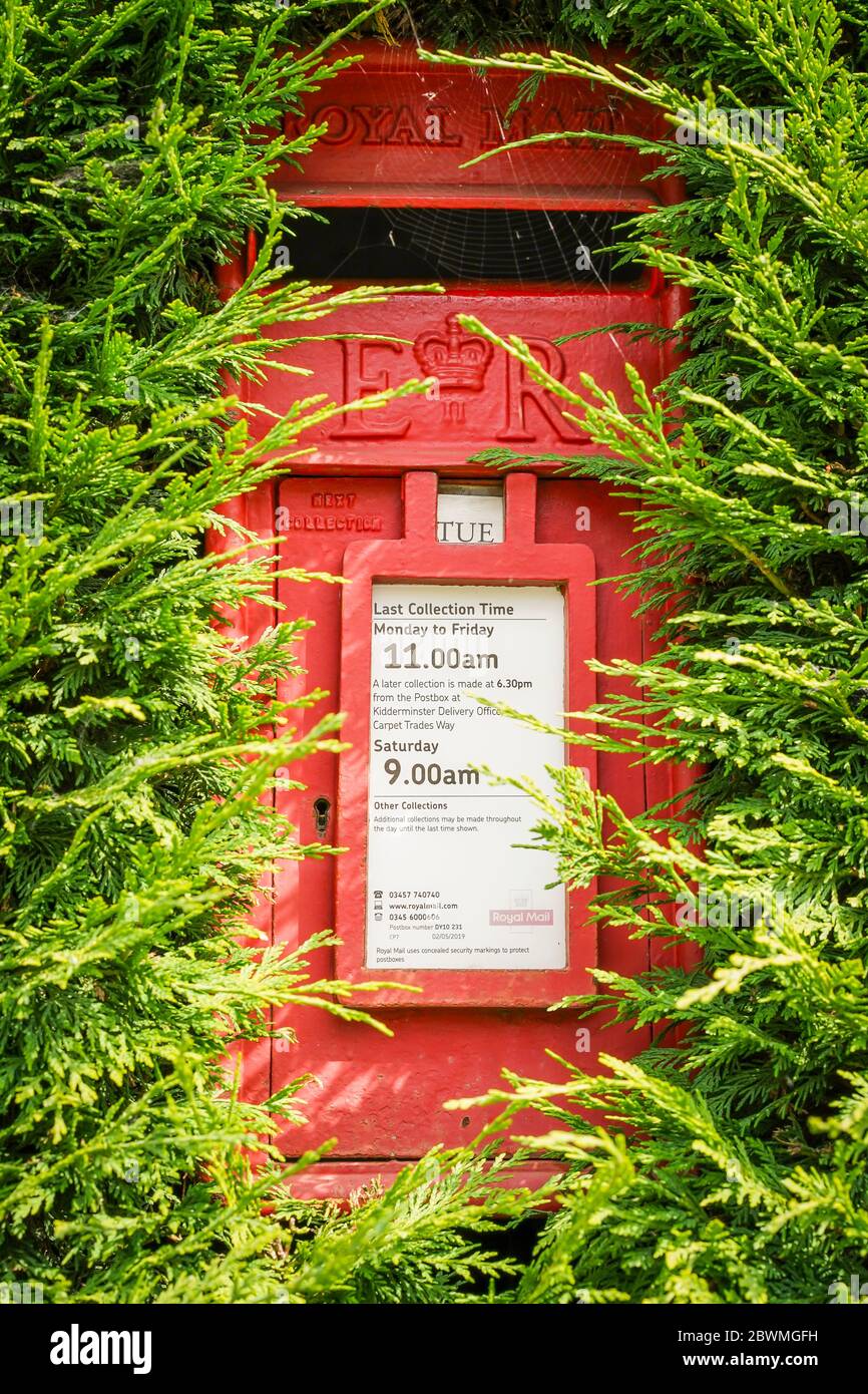 Close up of rural, village Royal Mail post box isolated outdoors hidden ...