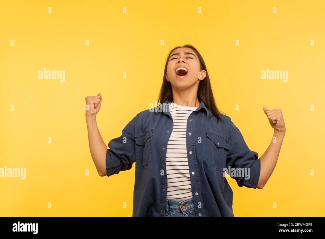 I'm champion! Portrait of thrilled enthusiastic girl in denim shirt ...