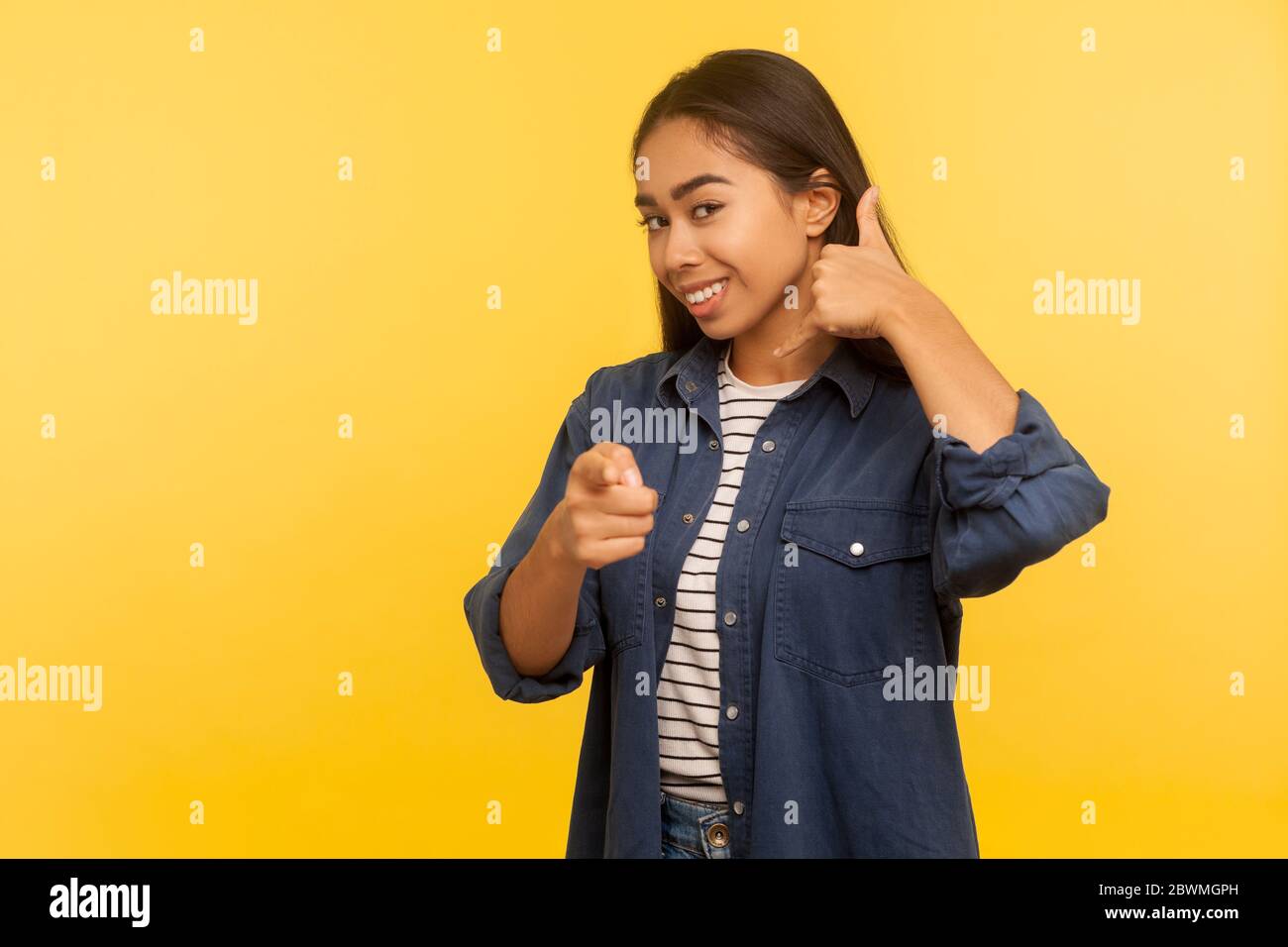 Hey you, call me! Portrait of playful girl in denim shirt standing with ...