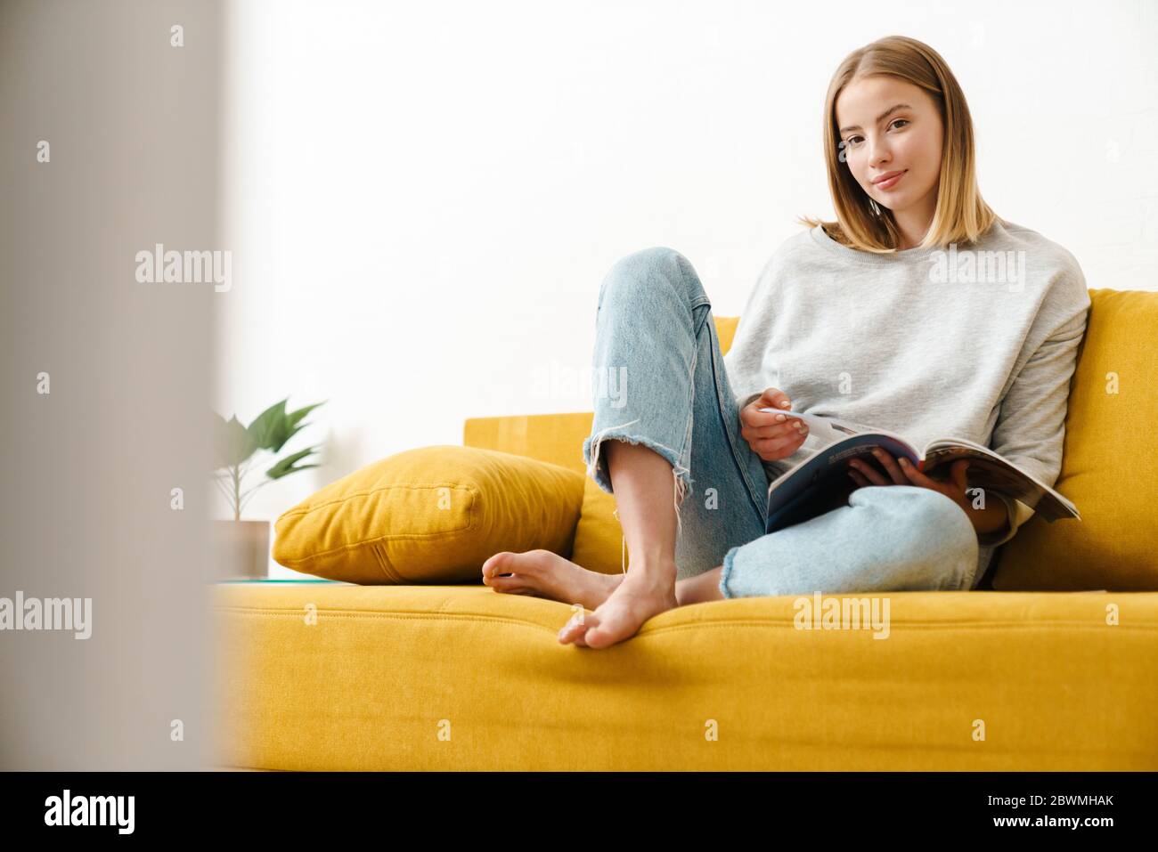 Beautiful smiling young blonde woman wearing casual clothes resting on ...