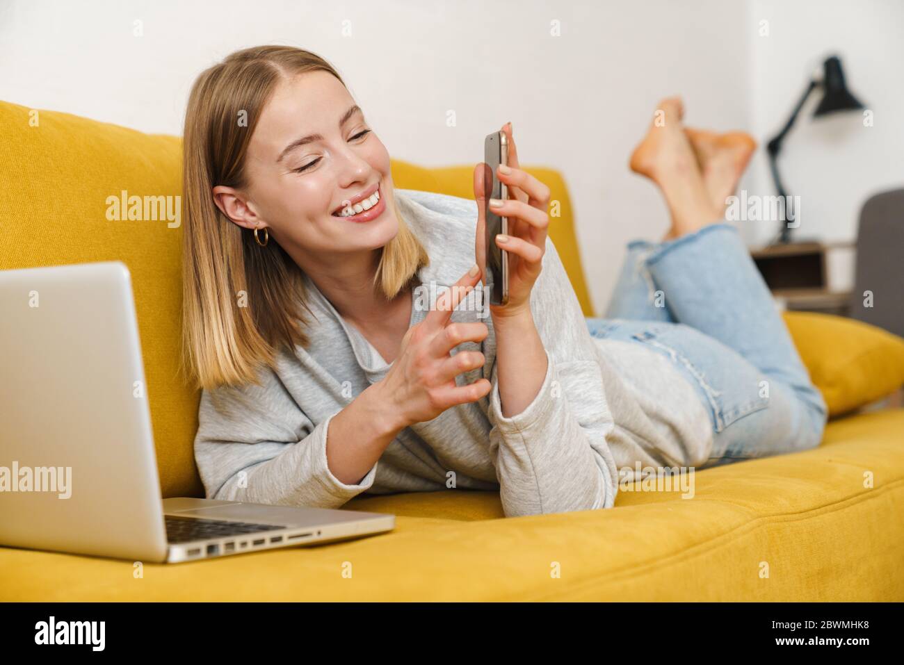 Beautiful smiling young blonde woman wearing casual clothes resting on ...