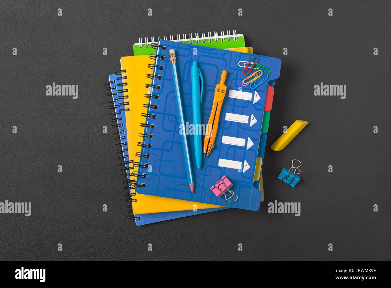 School concept, notebooks and pens on a black school board. top view ...
