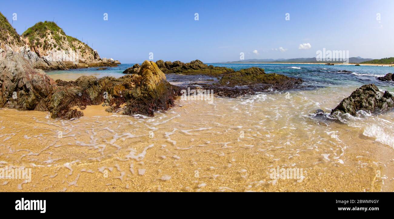Shallow water covers the sand and rocks of Mayto Beach in Mexico Stock ...