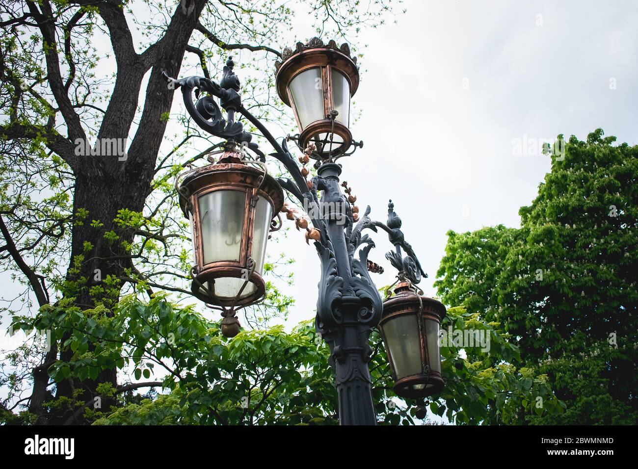 Classic triple streetlight with glass lamps Stock Photo - Alamy