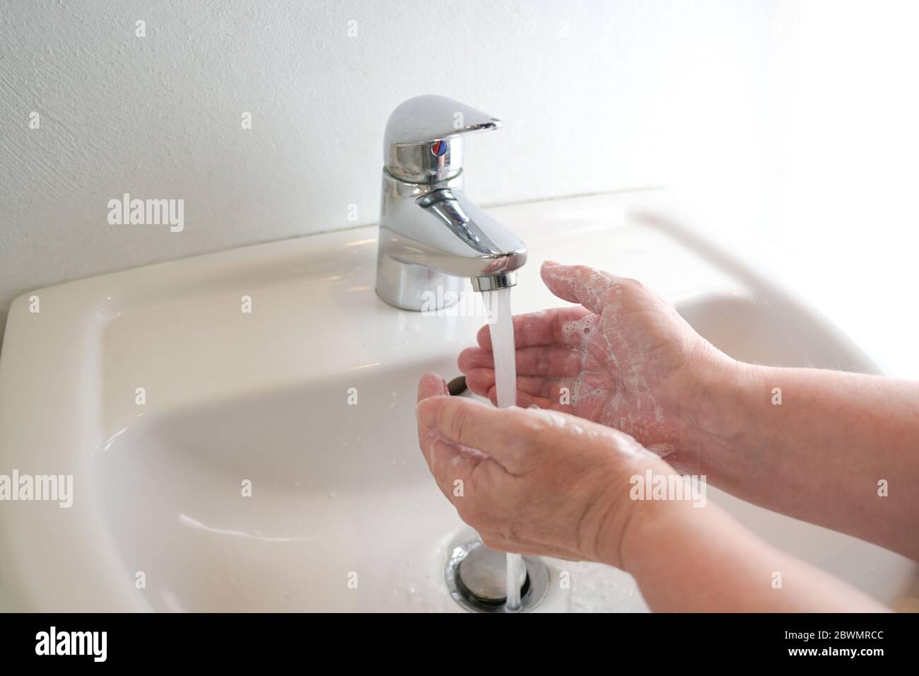 Washing hands under the faucet with water and soap, hygiene concept ...