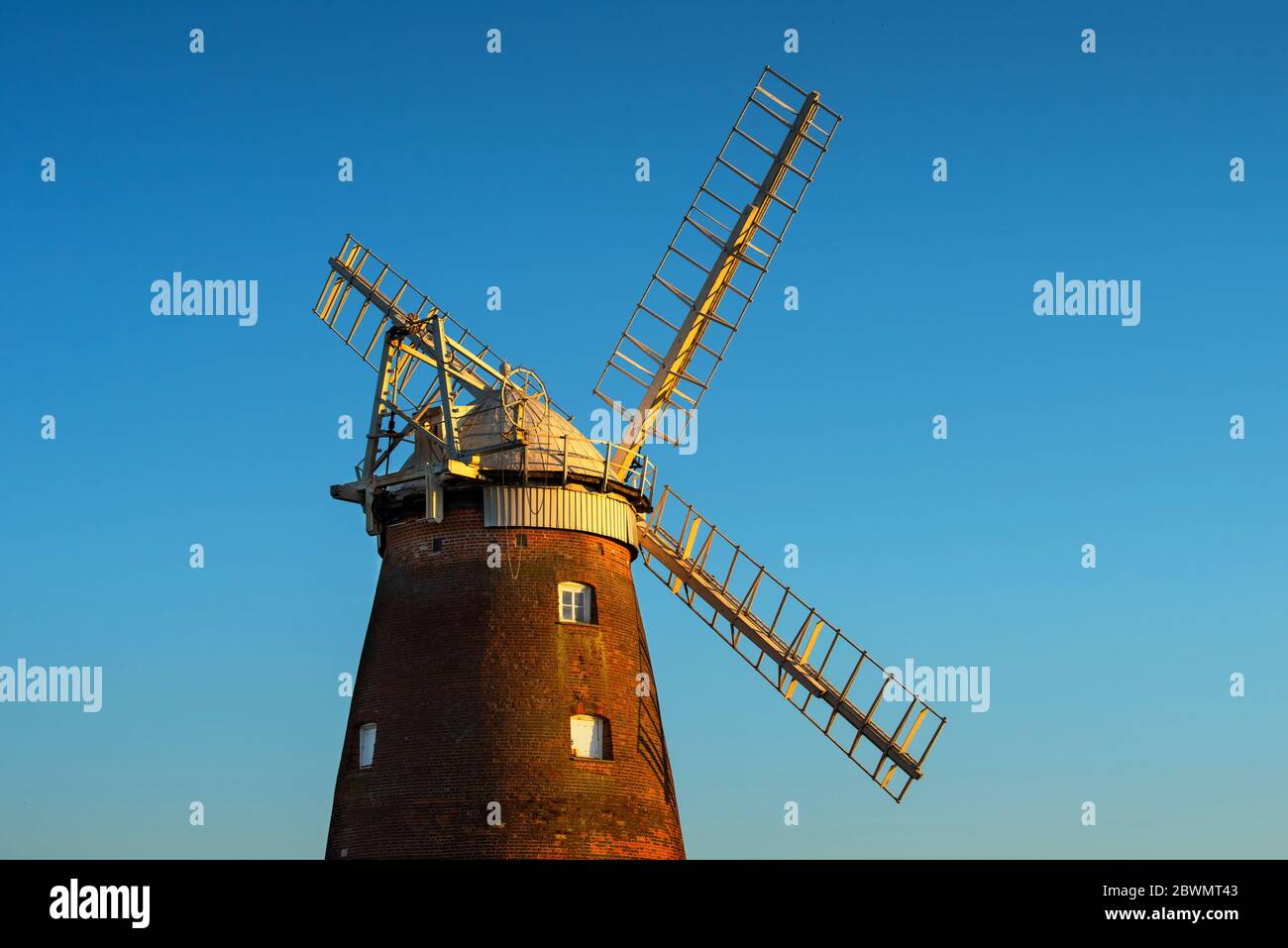 Thaxted windmill against a blue sky lit by the setting sun. May 2020 ...
