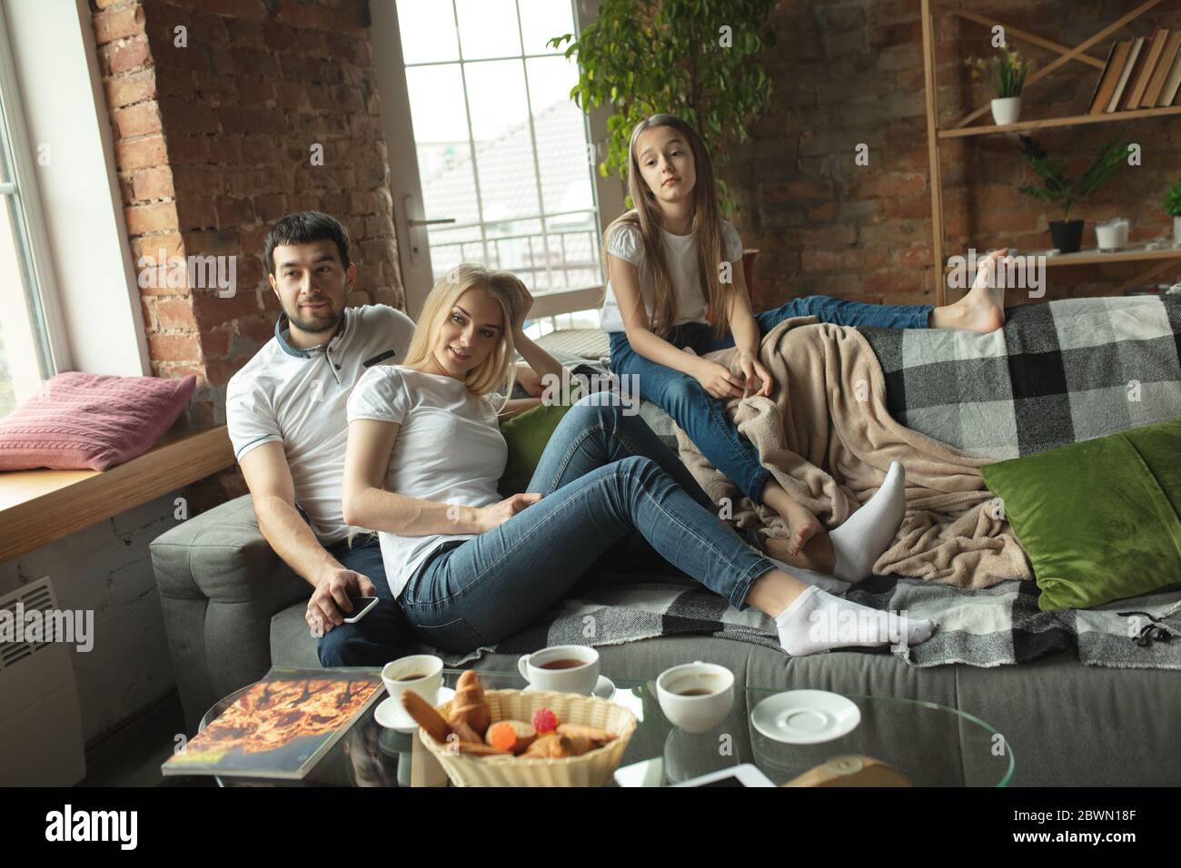 Mother, father and daughter at home having fun, comfort and cozy ...