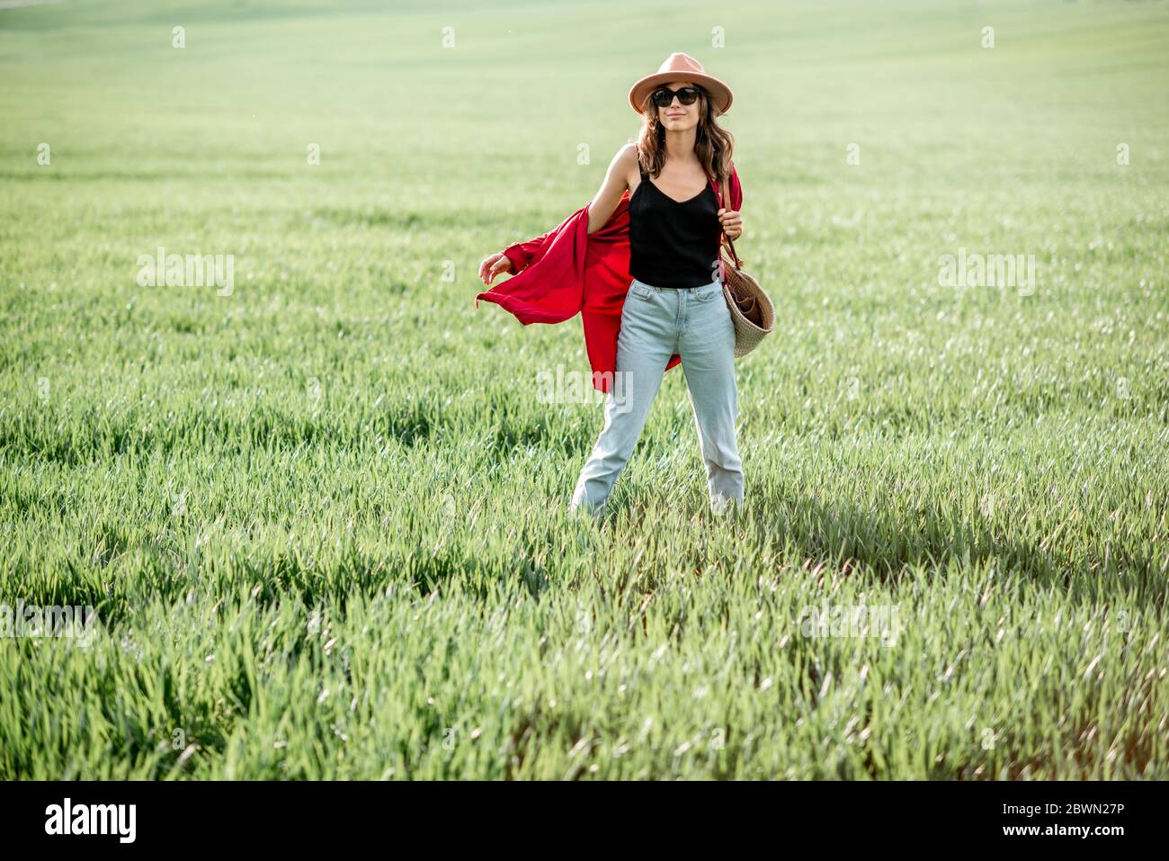 Portrait of a stylish carefree woman on the greenfield enjoying nature ...