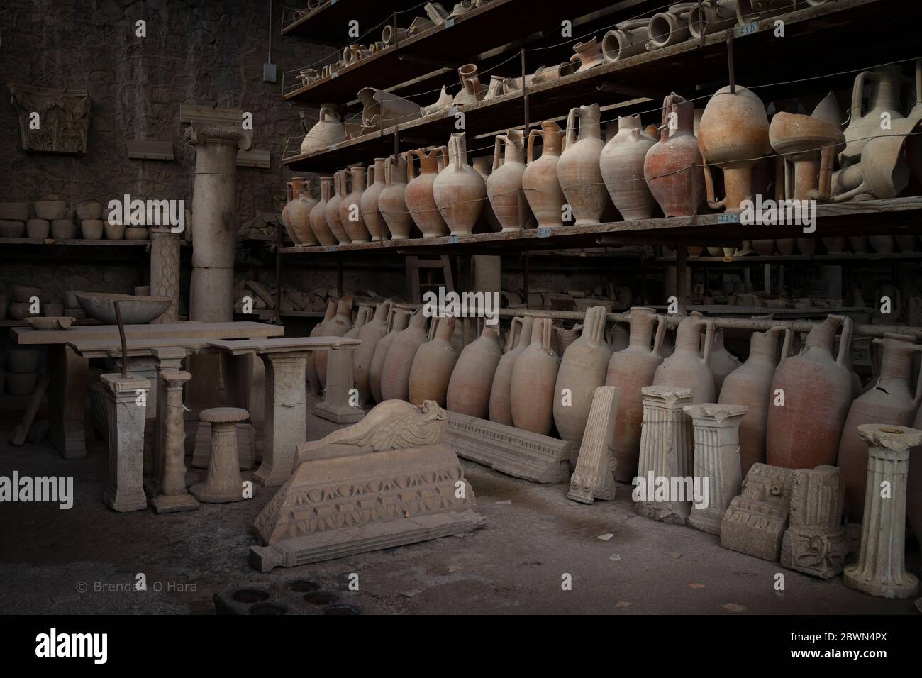 Collection of ancient Greek amphoras, altars, small fluted columns, and ...