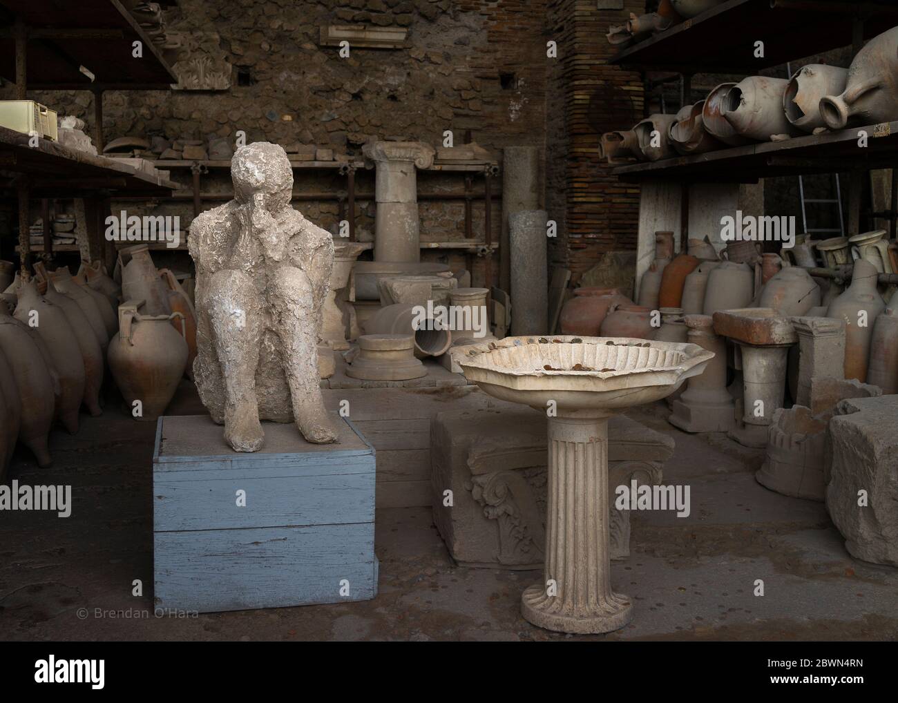 Plaster cast of human figure, with hands clasped and body in a fetus ...