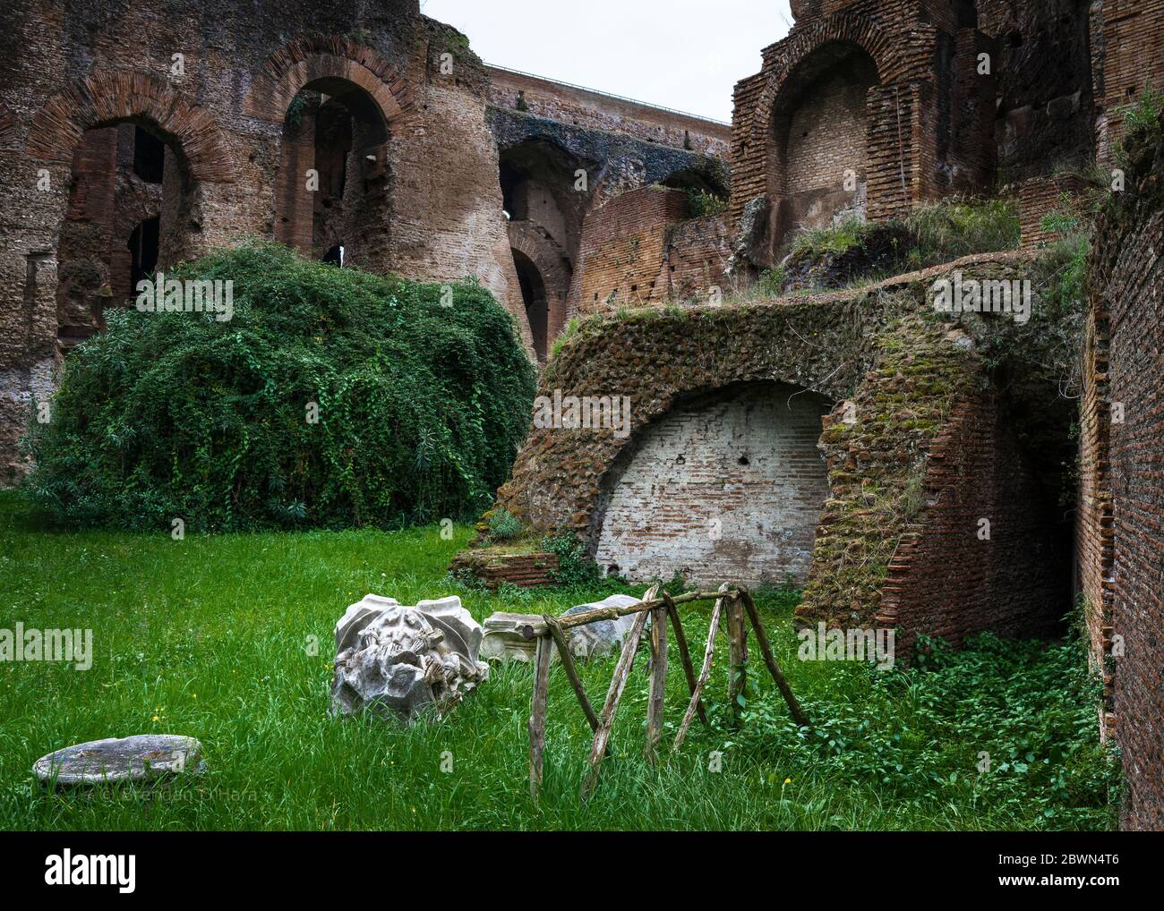 Verdant grassy area below towering brick arches at roman ruins near the ...