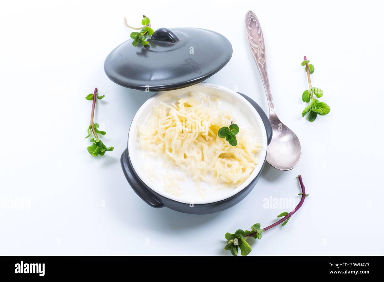 sweet boiled vermicelli with milk in a ceramic bowl isolated on white ...