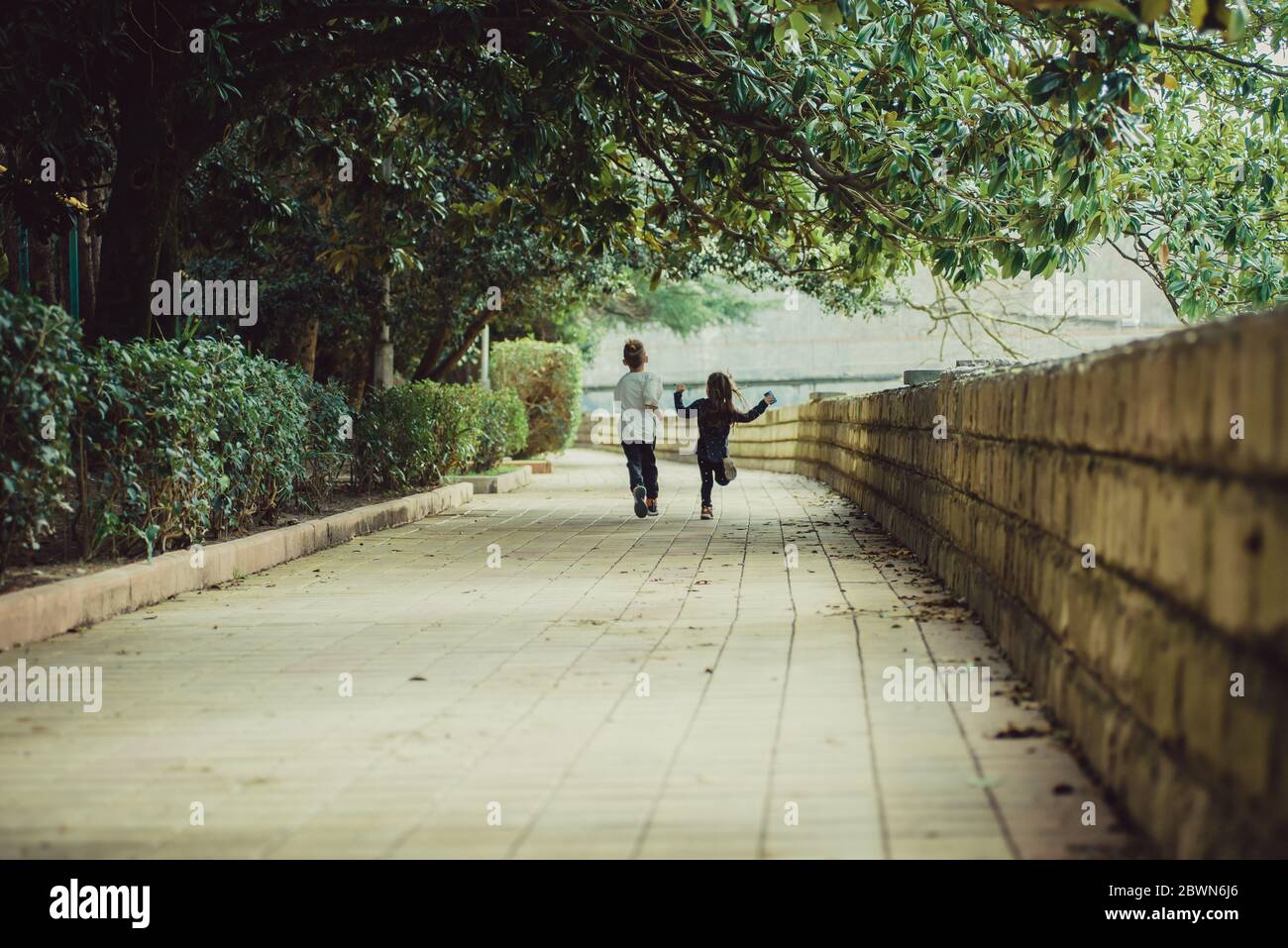 two happy kids running away from the camera Stock Photo - Alamy