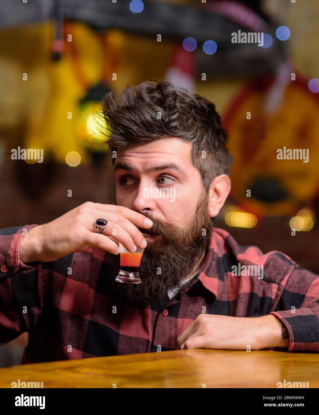 Hipster on thoughtful face drinks shot cocktail. Depression and ...