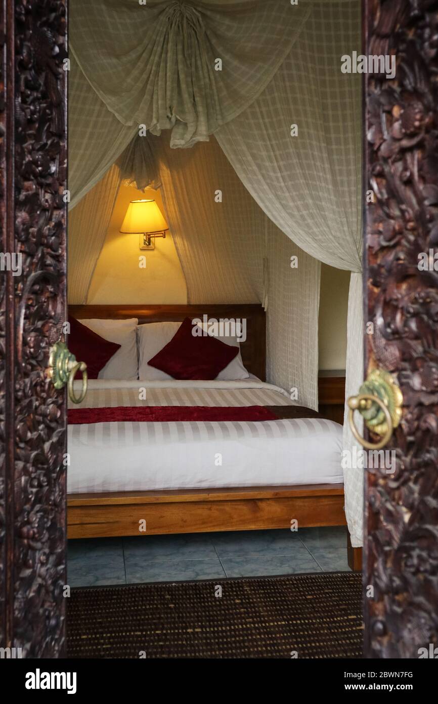 Traditional balinese bed with canopy. View through the opening of ...