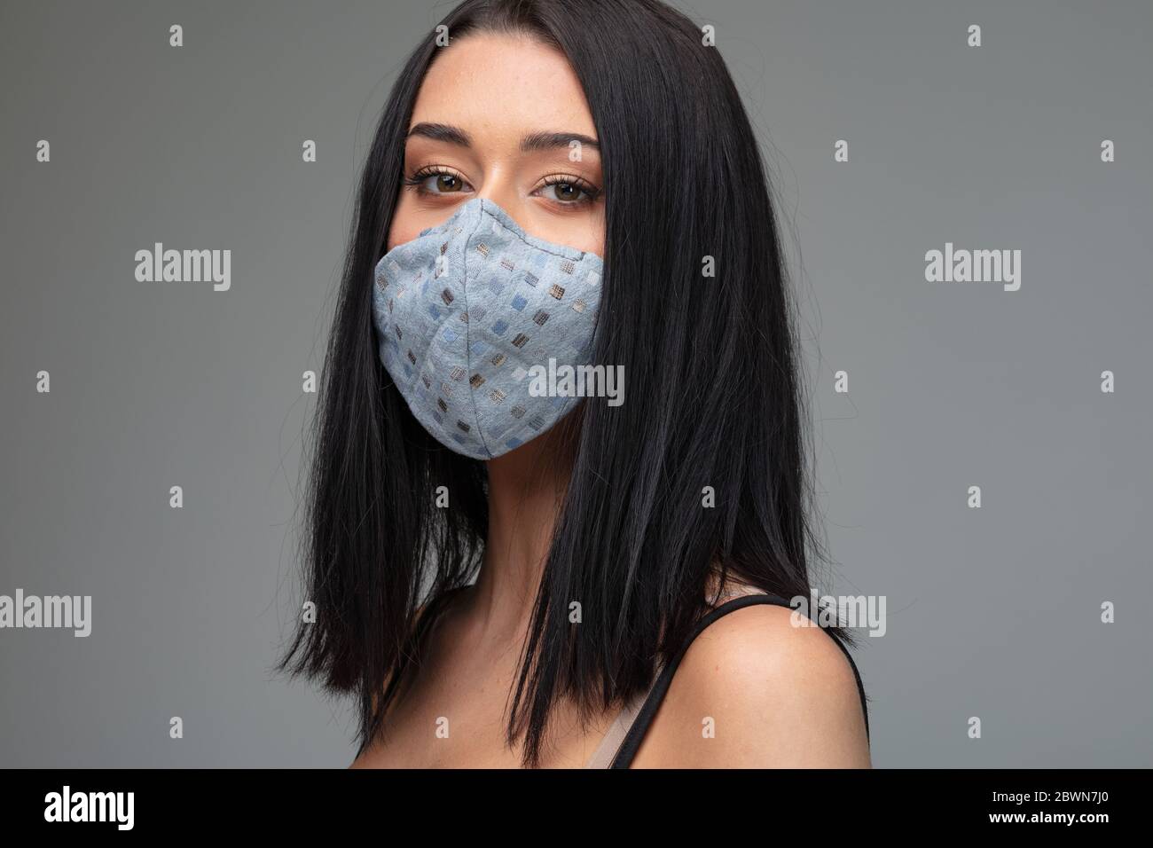 Young woman in a fashionable textile face mask in patterned fabric ...