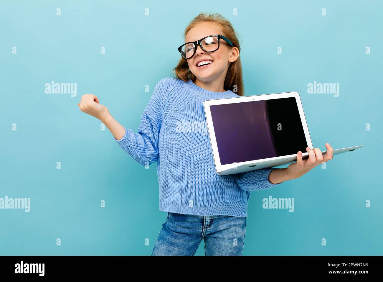 joyful european girl holding a computer in her hands with mockup on a ...