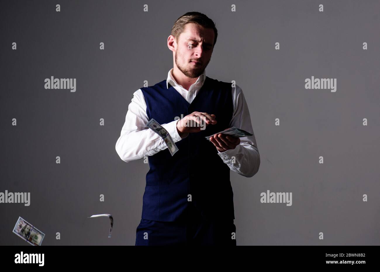 Man in formal wear, businessman throwing money on grey background. Rich ...