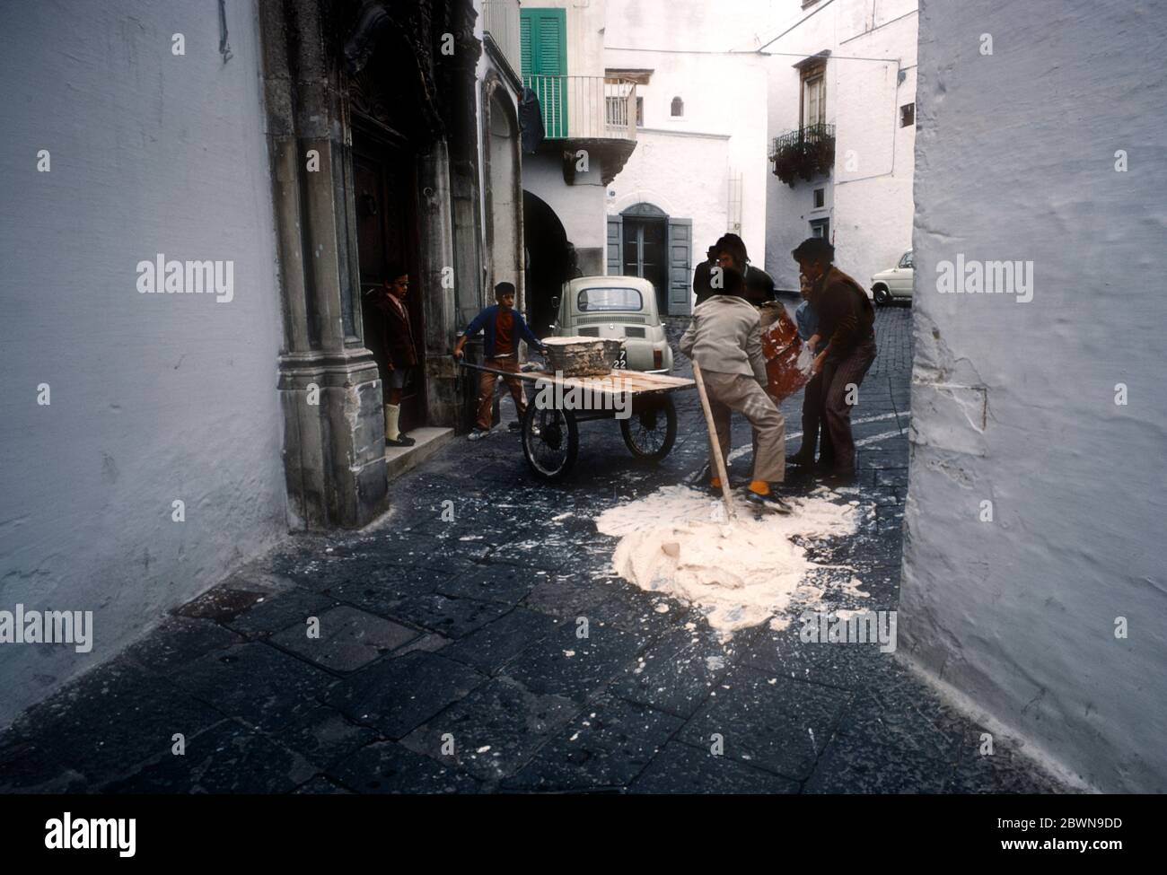 People lifting cement onto a carriage following a spillage in the city ...