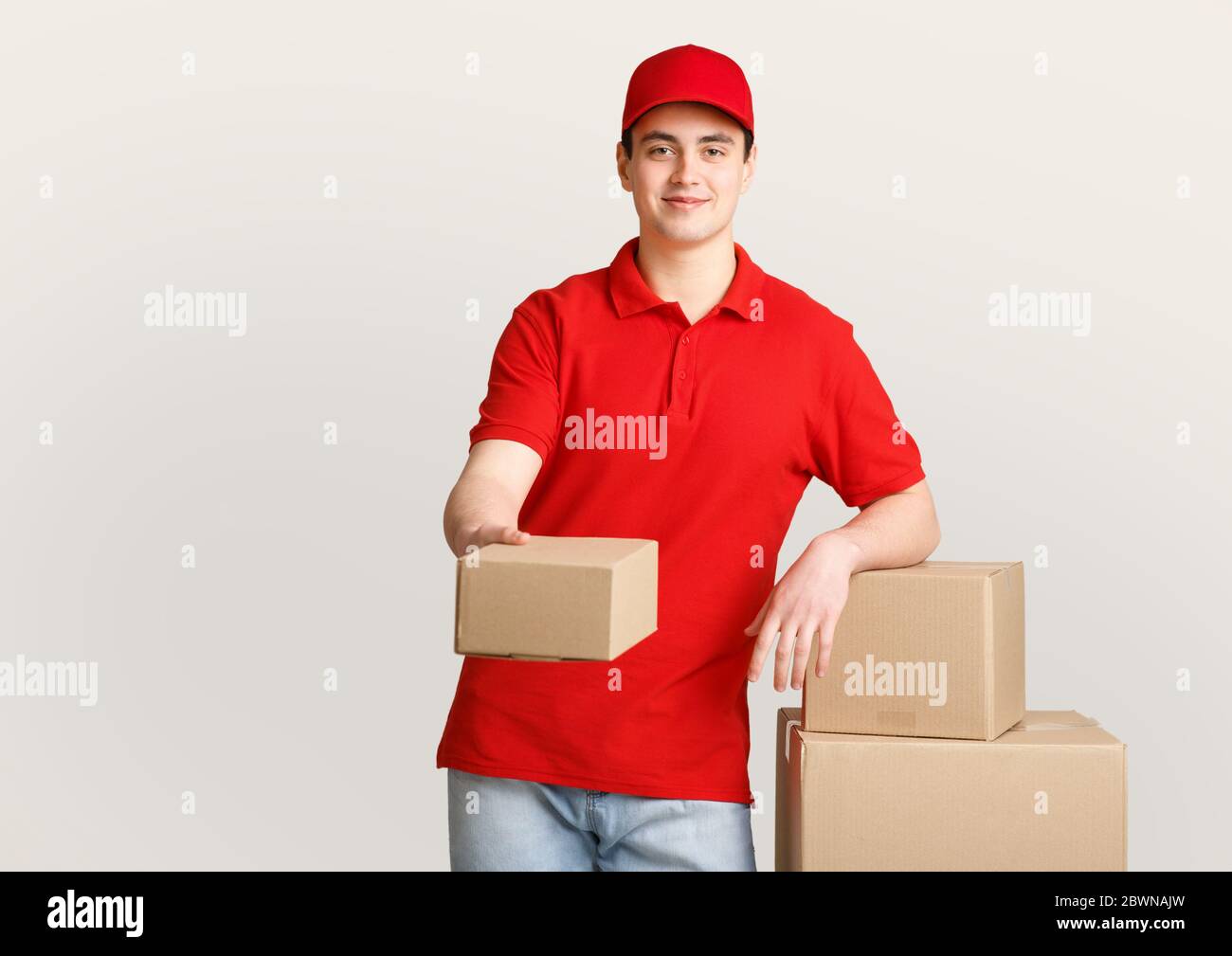 Delivery of parcels in modern post. Courier in uniform gives parcel ...
