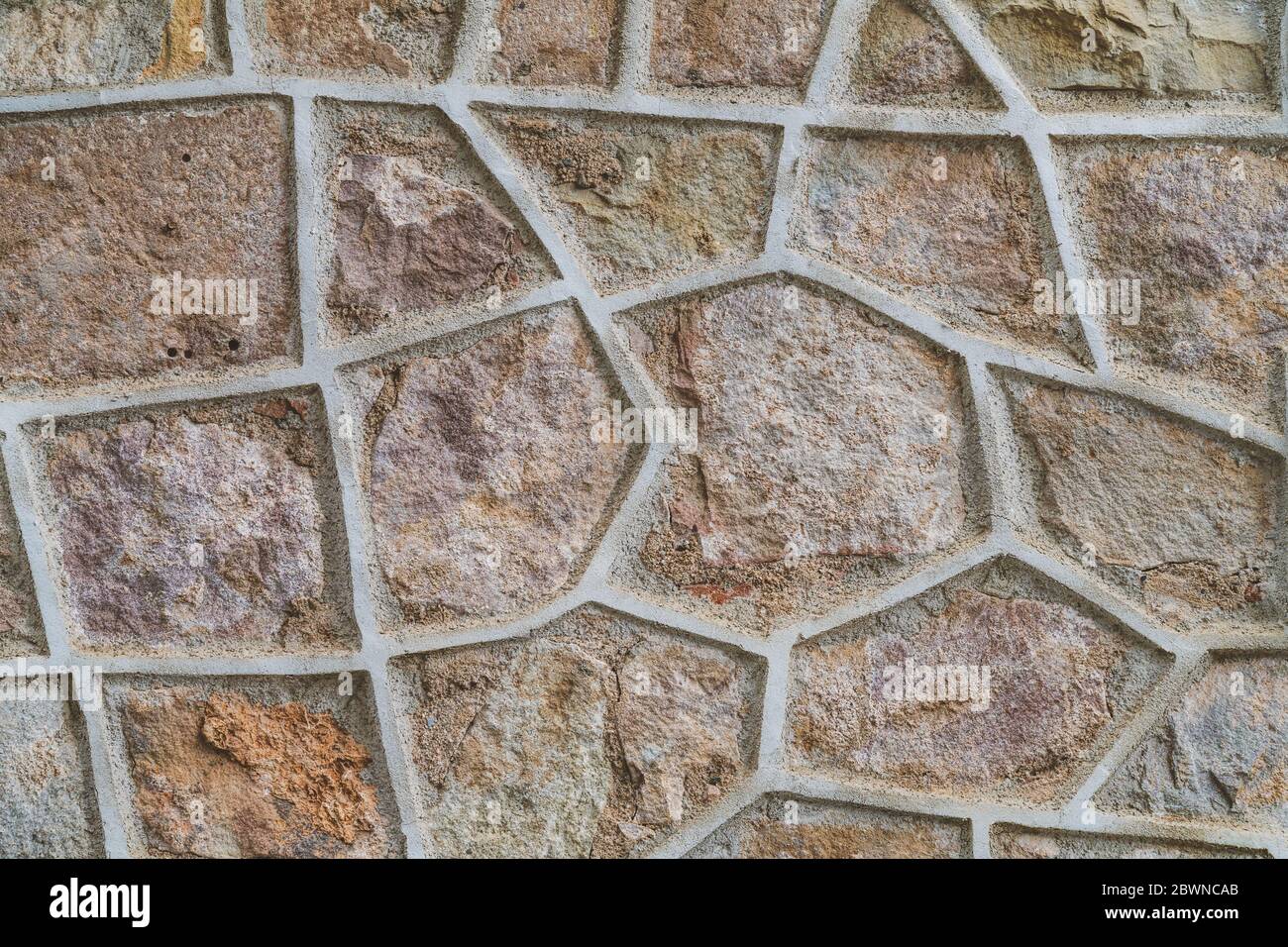 Background of an old natural stone wall with concrete divider shapes ...