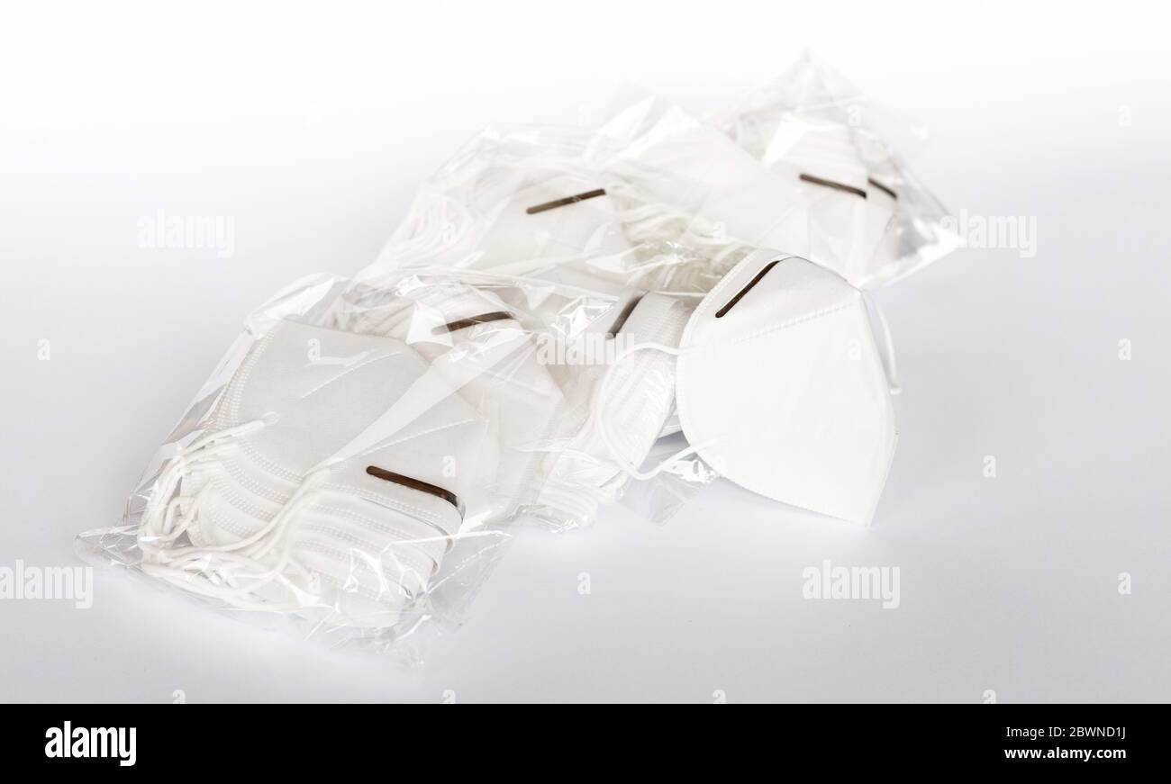 Group of simple white protective KN95 face masks in plastic packages ...