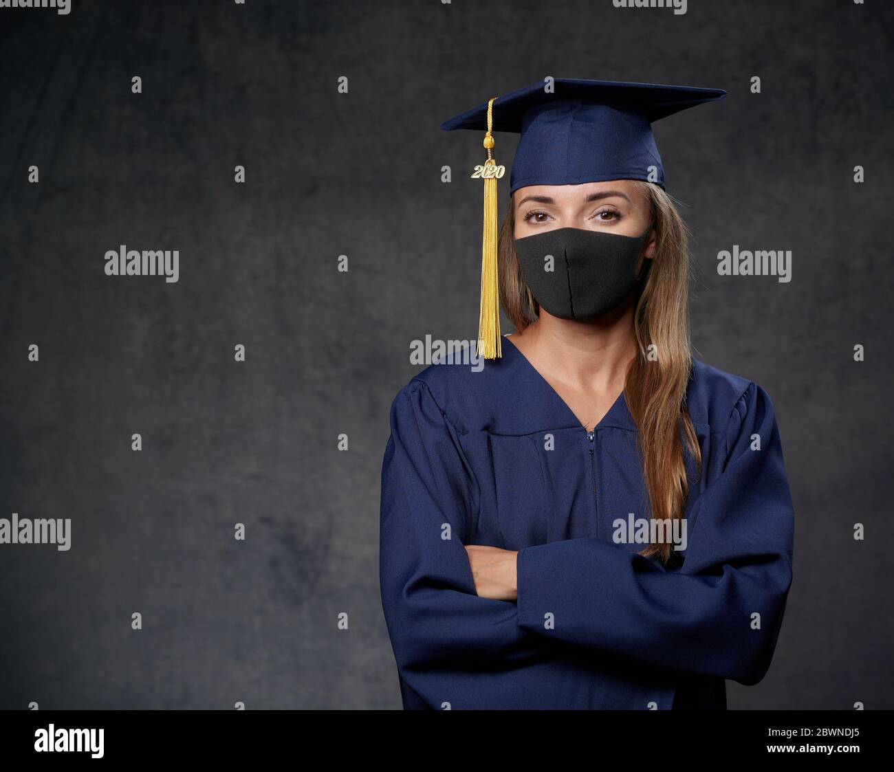 Young woman graduate in black mask with hands crossed celebrating her ...