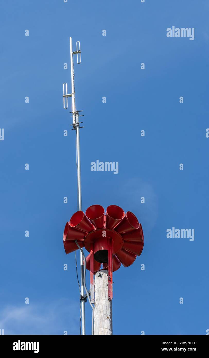 Red Fire house sirens on a wood pole with dipole antennas attached ...