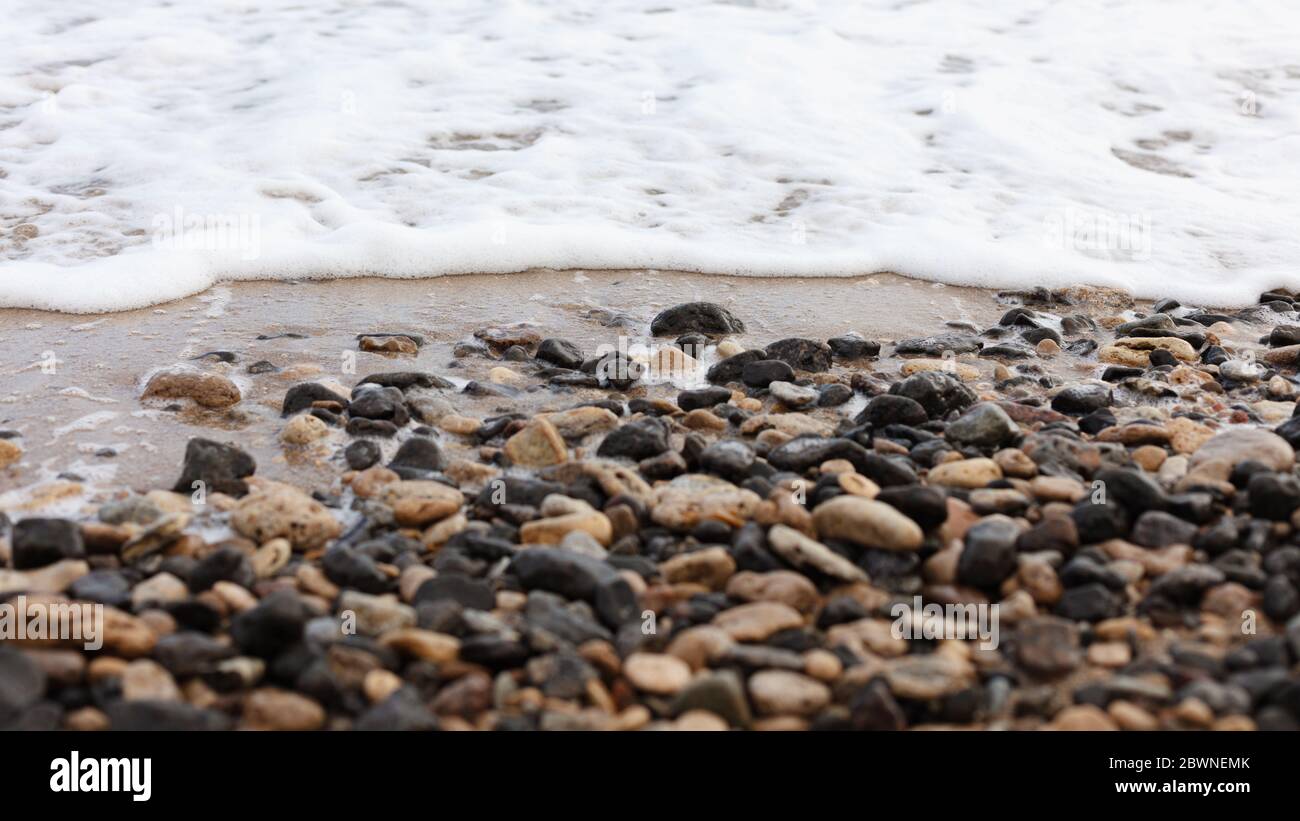 Different texture on the beach - water and sand, stones and pebbles ...