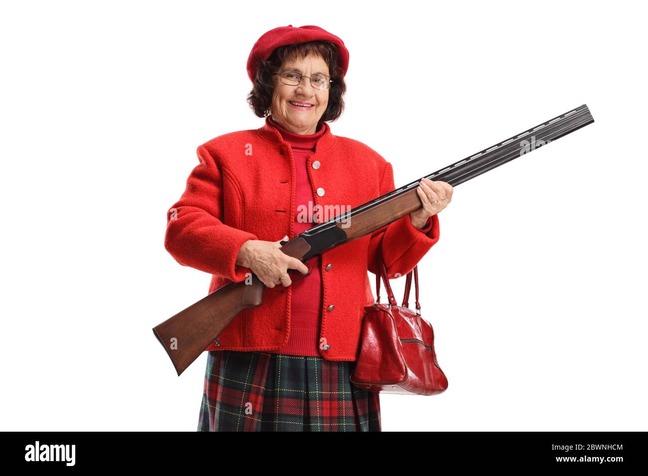 Elderly lady smiling and holding a shotgun isolated on white background ...