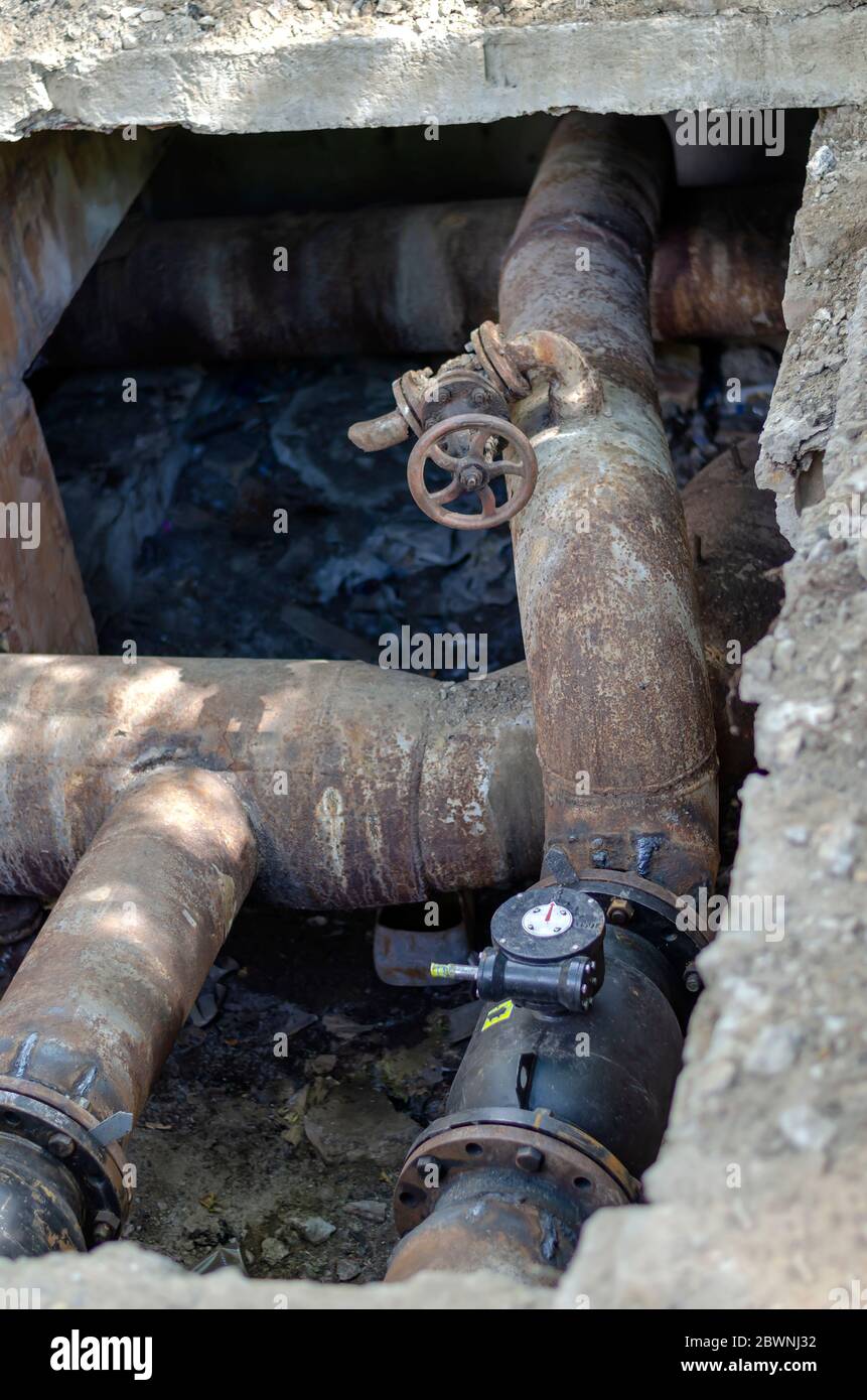 An open underground pipeline with valves in a brick well. Underground ...