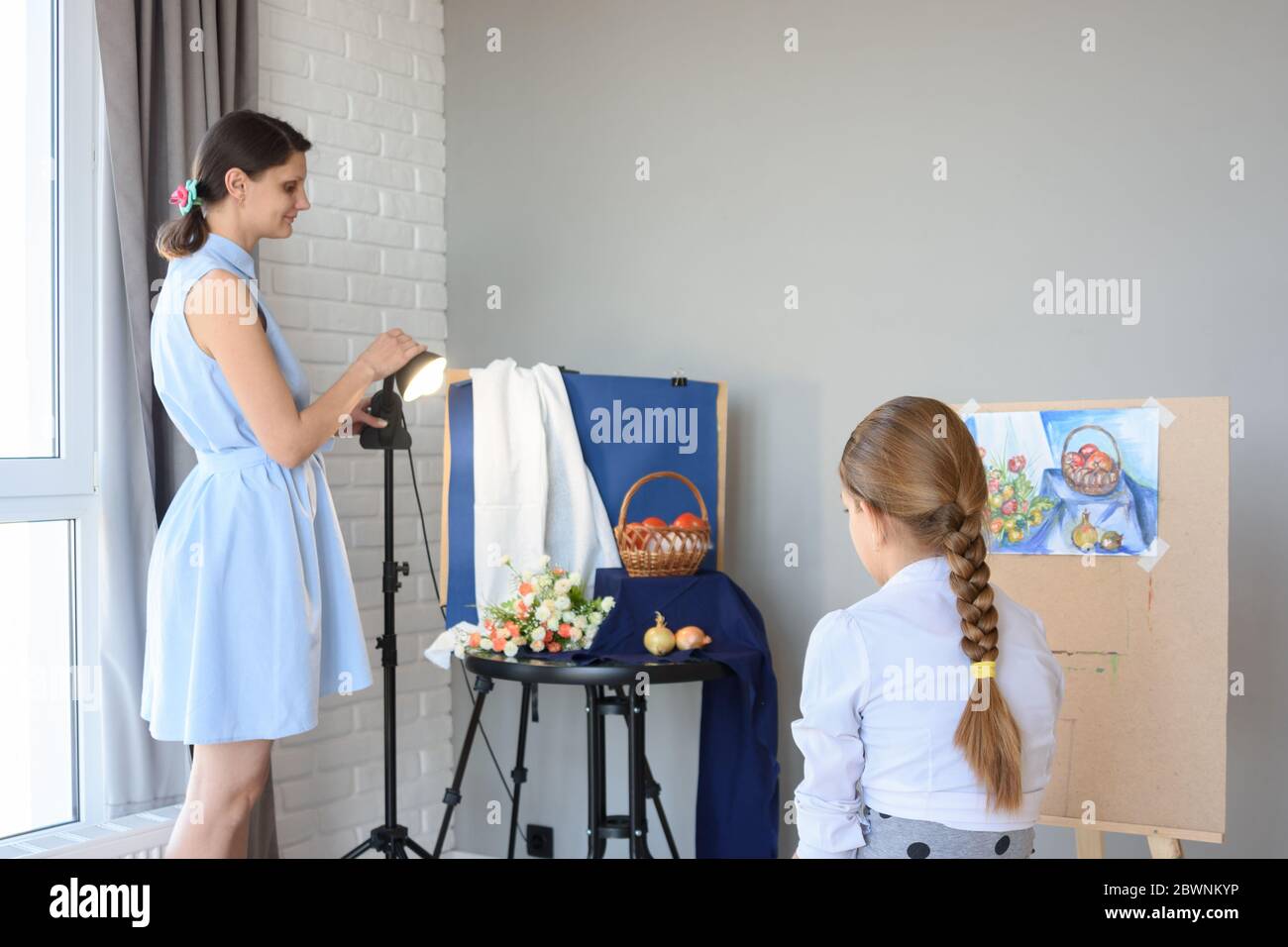 An art school teacher explains to a student how to draw a still life ...