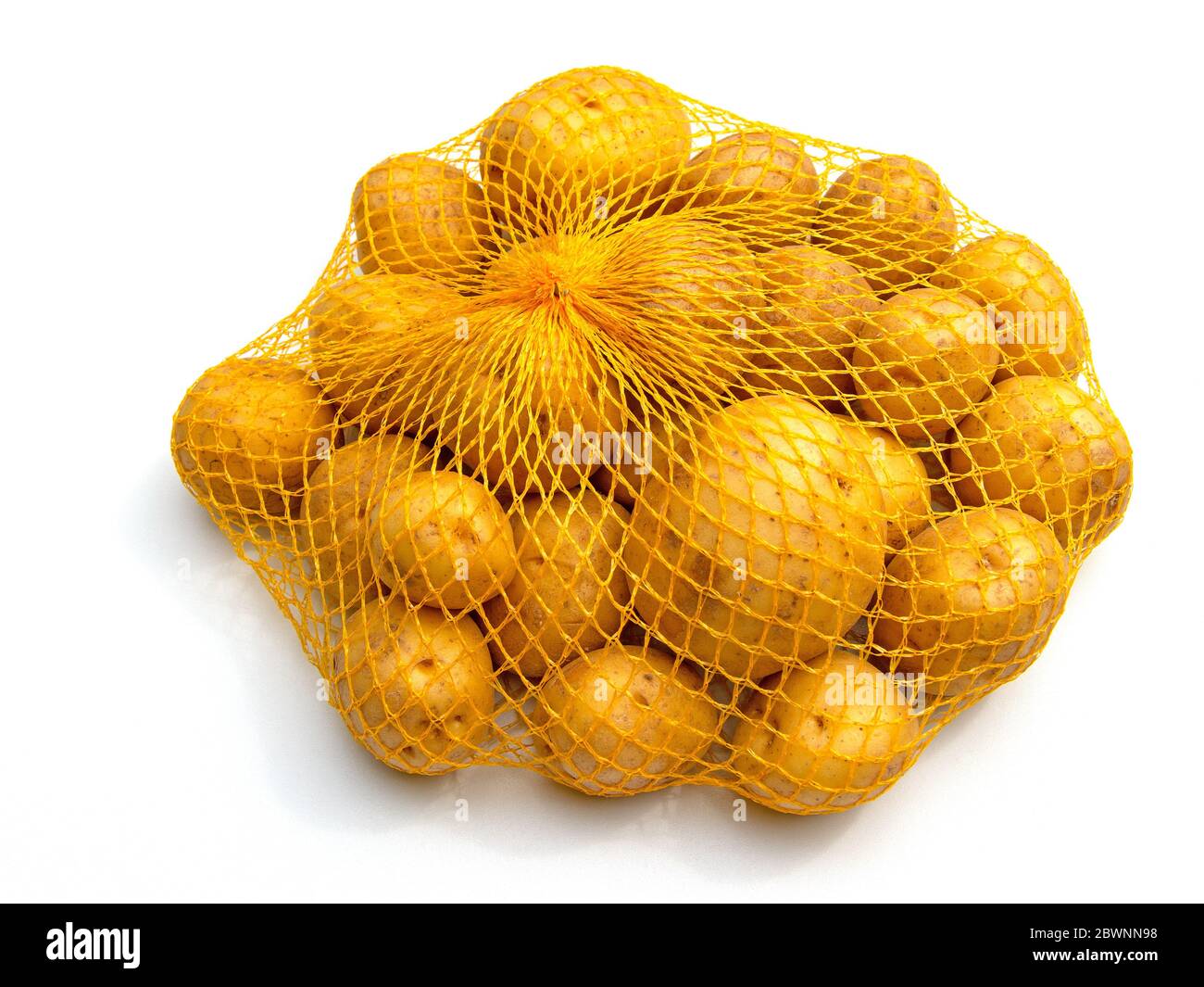 Potatoes in a net against white background Stock Photo - Alamy
