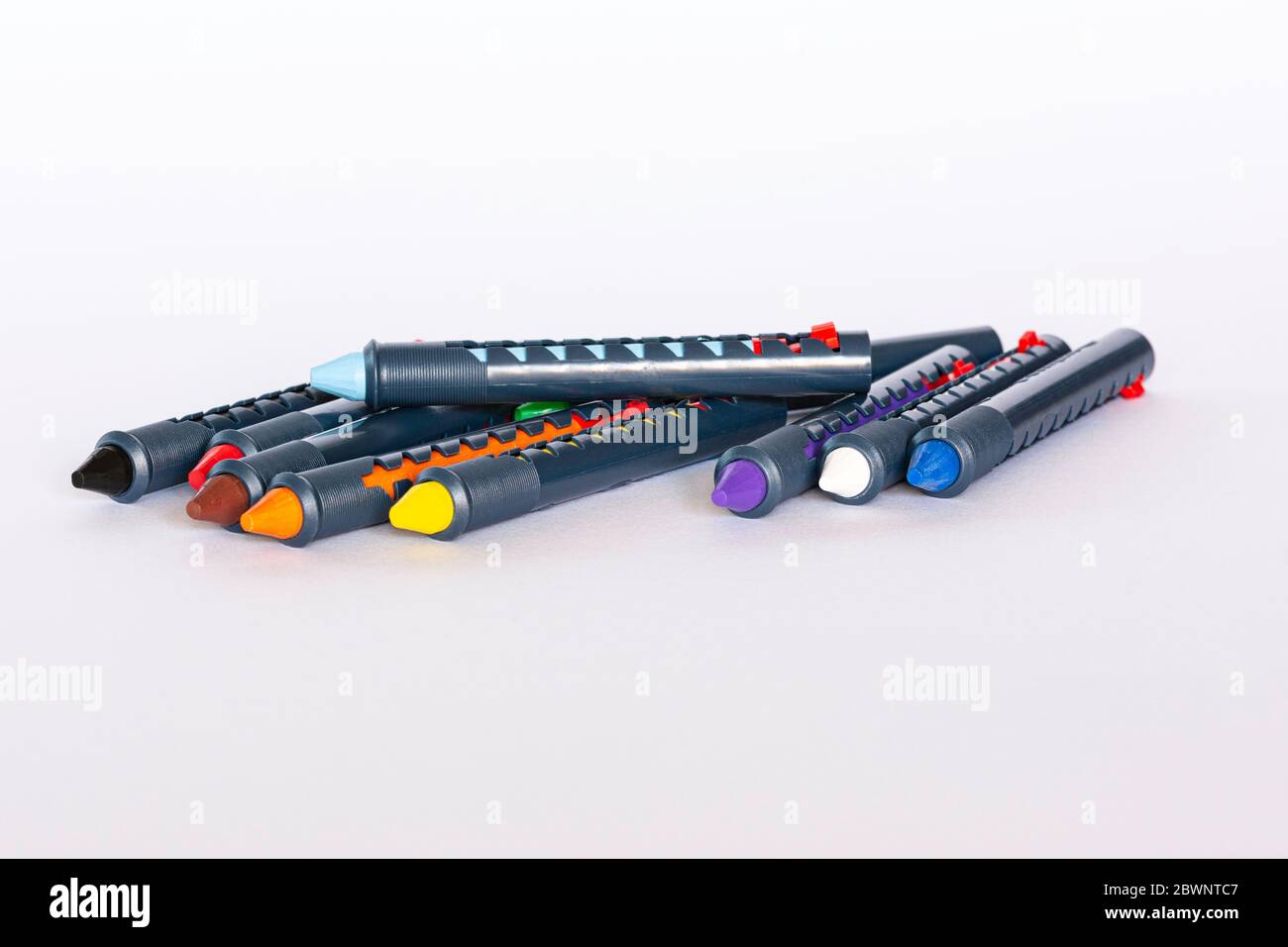 Ten different colored crayons, unsorted, placed on a white background ...