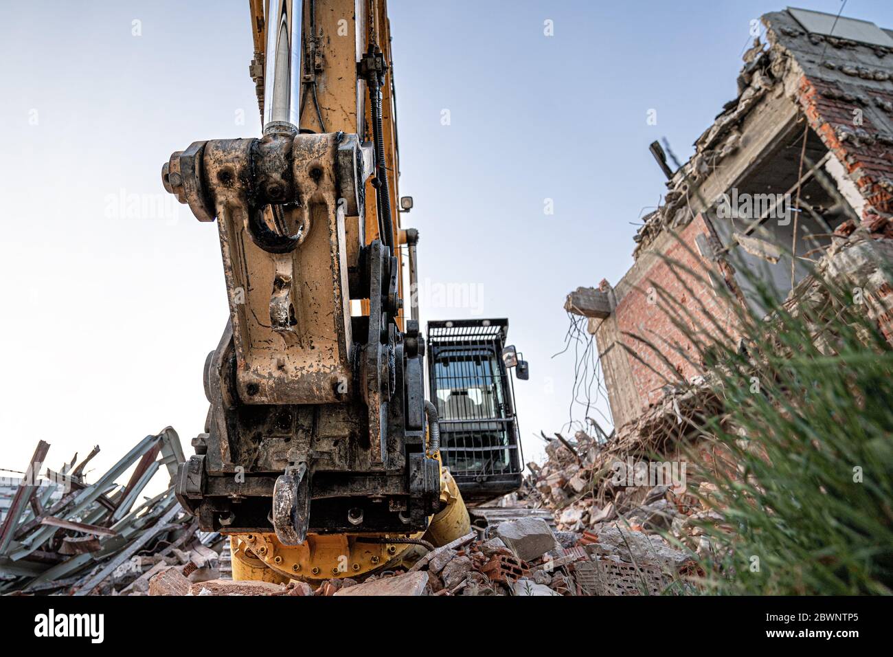 Excavator destroing ruins and olfd building. Wide angle closeup shot ...