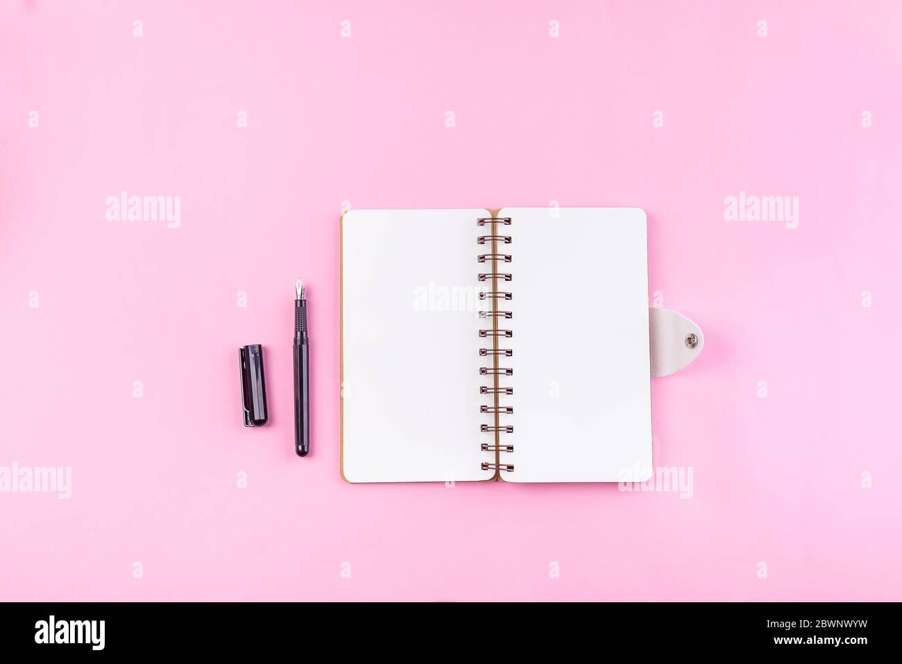 school notebook on a pink background, spiral notepad on a table, flat ...