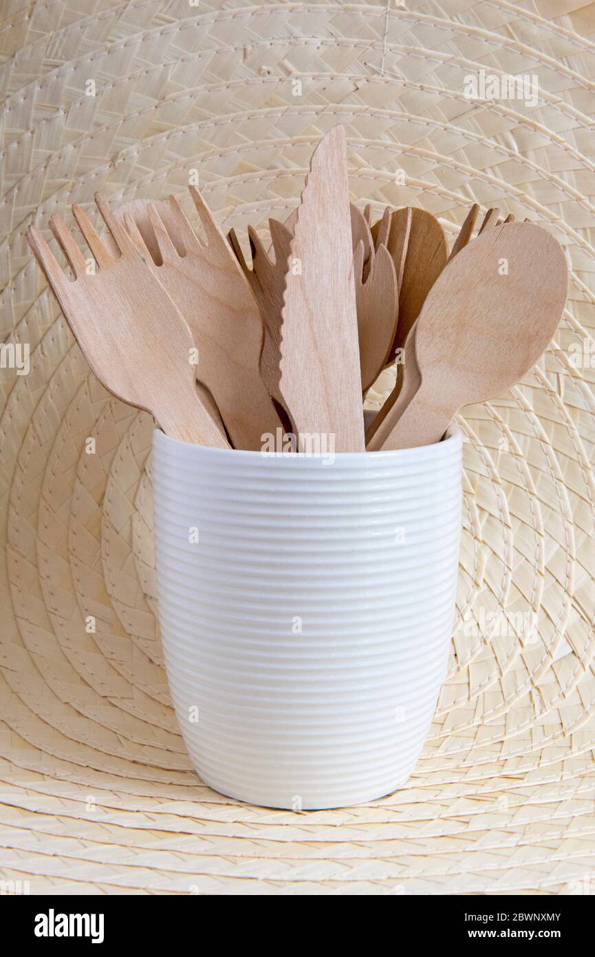 Wooden Cutlery in ceramic pot with palm leaf background. Zero waste ...