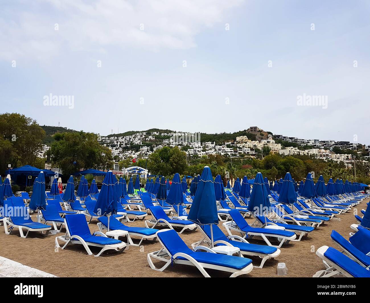 Lots of blue sunbeds with umbrellas at the sea beach Stock Photo - Alamy
