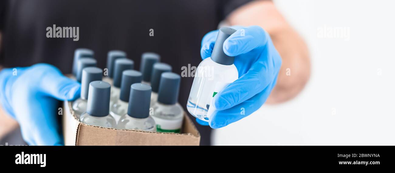 Hand sanitizer hygiene alcohol gel bottles in hands of man wearing ...